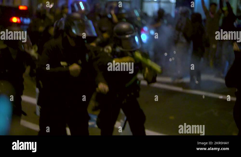 A group of riot police shout at and fire rubber bullets upon a crowd of ...