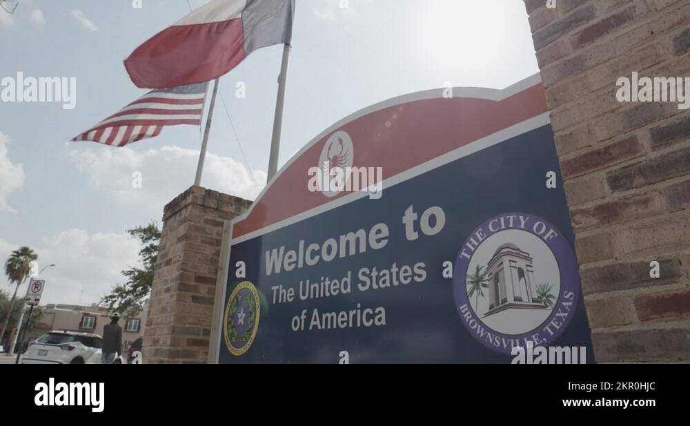 A 'Welcome to America' sign with US and Texas flags flying overhead ...