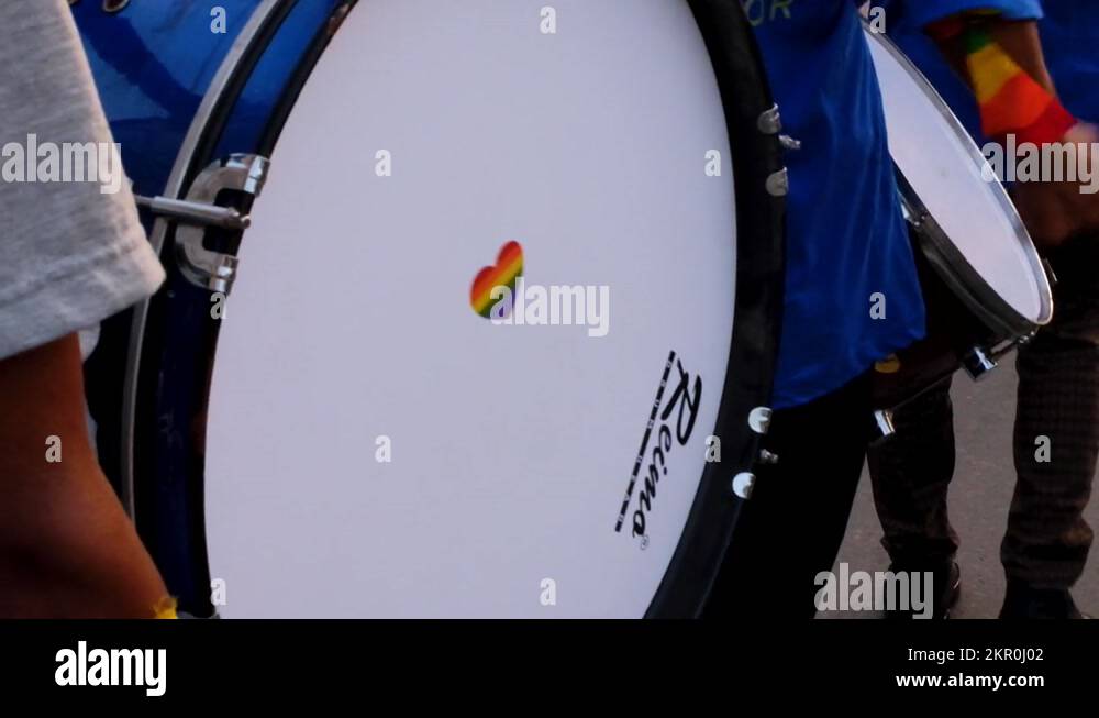 Person playing a drum in a marching band during PRIDE 2022 with a ...