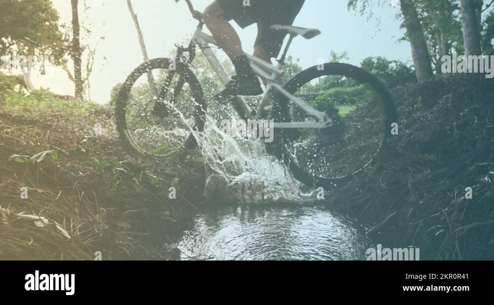 Spots of light against mid section of a man riding a bicycle through ...