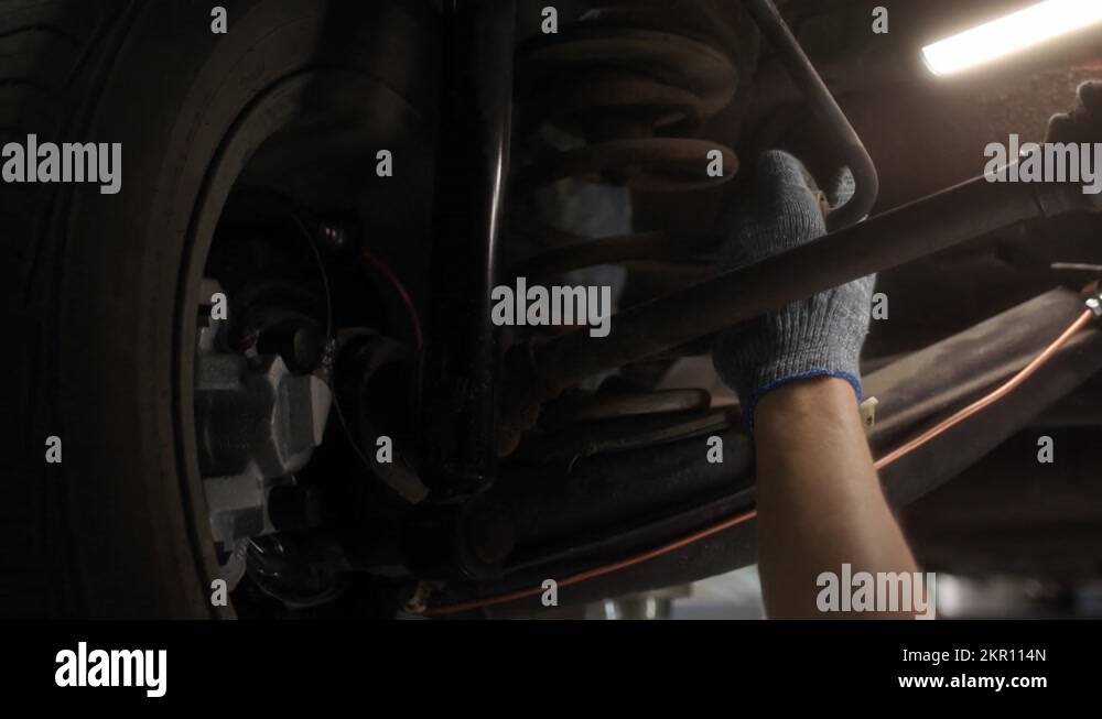 Close up woman hand mechanic in car servic checks suspension of car ...