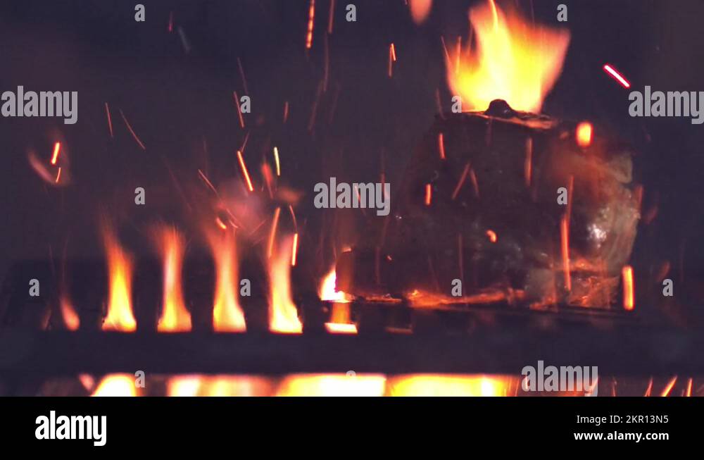 Pouring a burning alcohol based mixture on a thick cut of pork on a ...