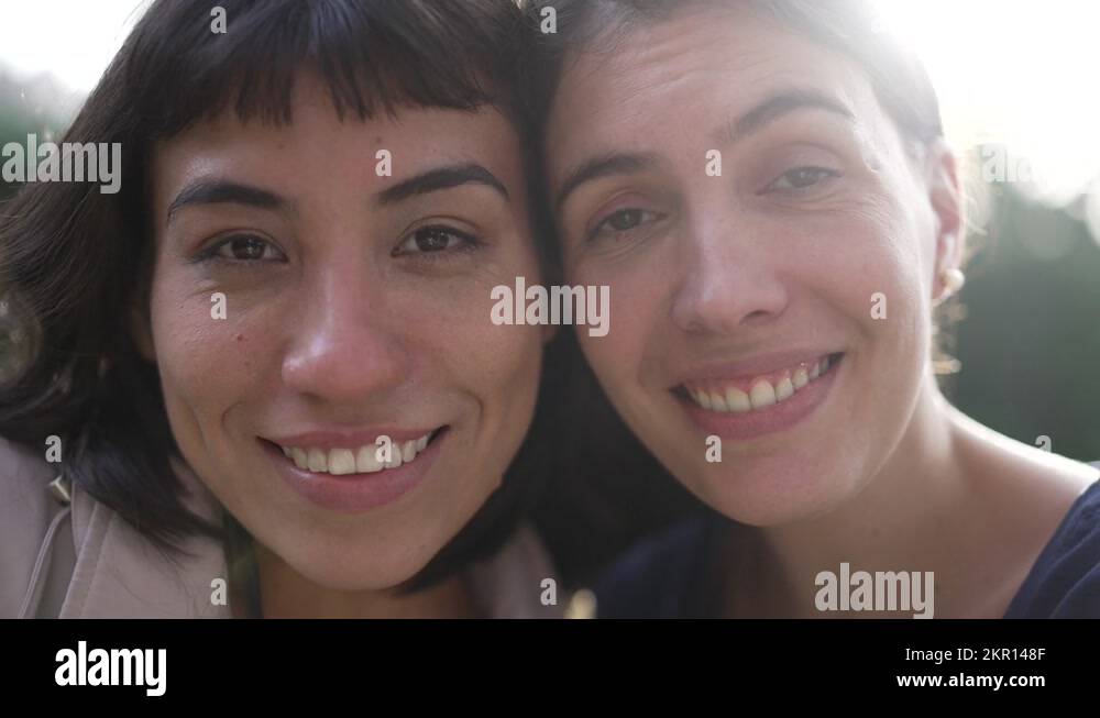Two young women faces together cheek to cheek. Portrait of diverse ...