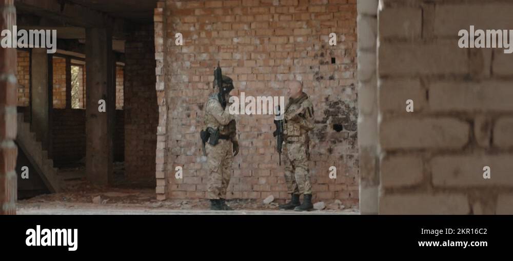 Two soldiers in full uniform talking inside of destroyed building Stock ...