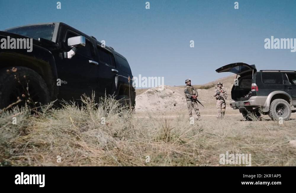 desert terrain. stands an armed soldier with a machine gun Stock Video ...