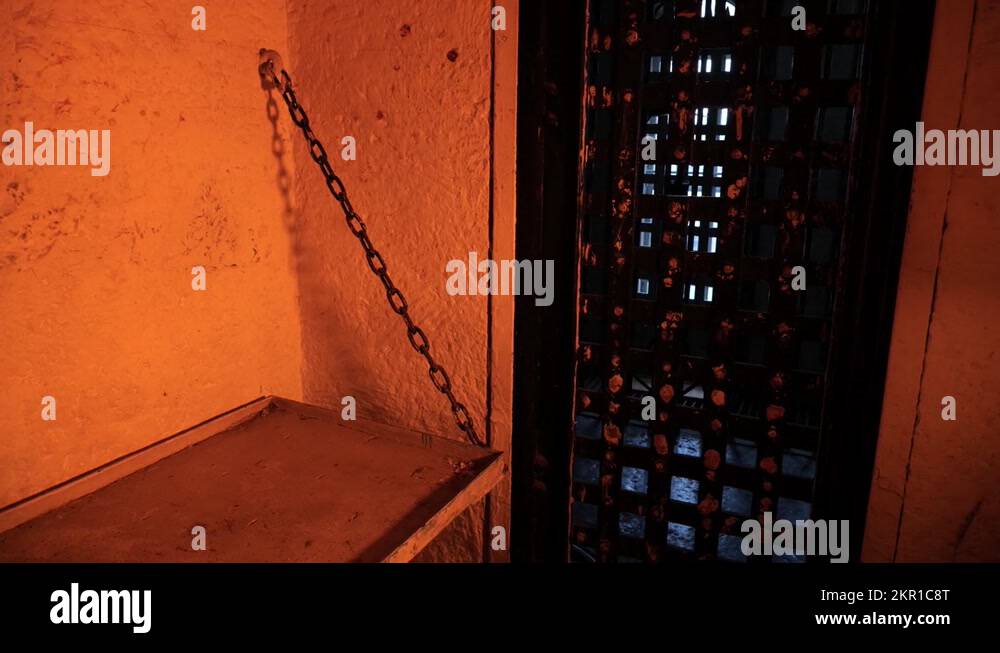 Historice 1800s jail cell with metal bunk and iron cell door in candle ...
