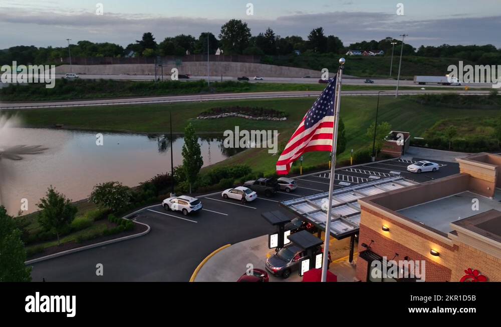 Busy Chick-Fil-A fast food restaurant at night. American flag at modern ...