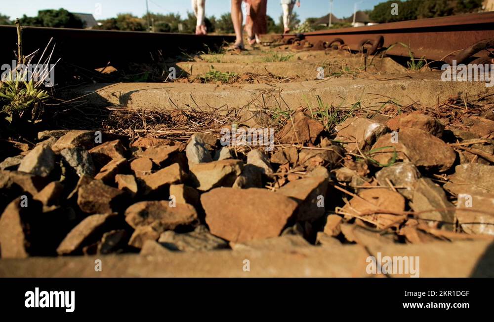 Family being silly on railroad tracks, parents help kids balance as the ...