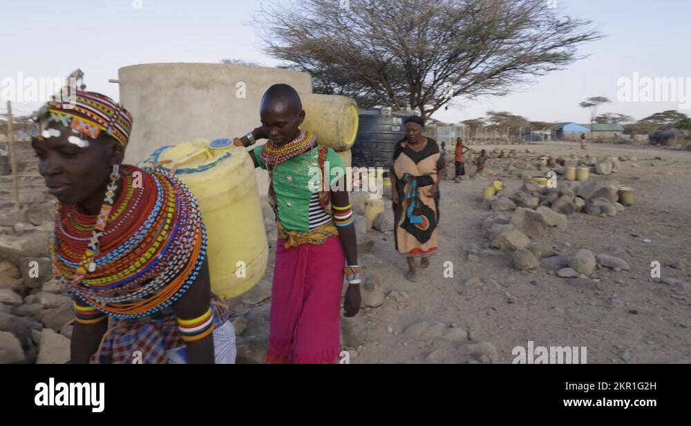 Climate change.drought.African woman carrying water in plastic barrels ...