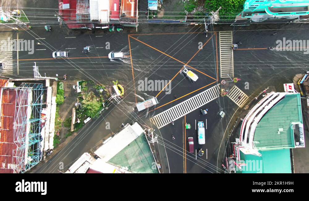 Flooded of rain water intersection, vehicles slowly driving, top down ...