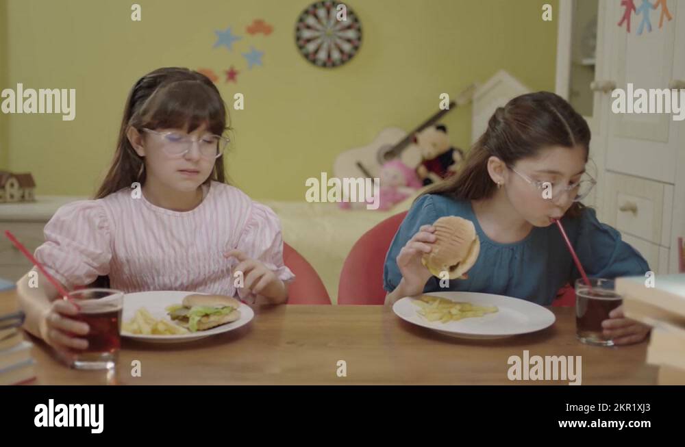 Little girls doing school homework are eating hamburgers Stock Video ...