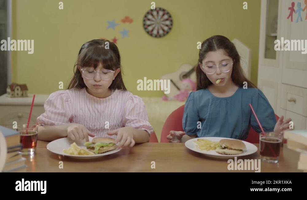 Little girls doing school homework are eating hamburgers Stock Video ...