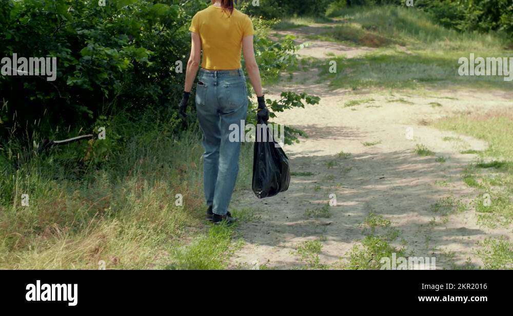 Woman collect trash in a trash bag Stock Video Footage - Alamy