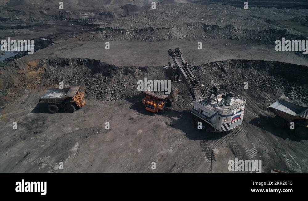 Loading queue from giant dump trucks to mining excavator. Open pit coal ...