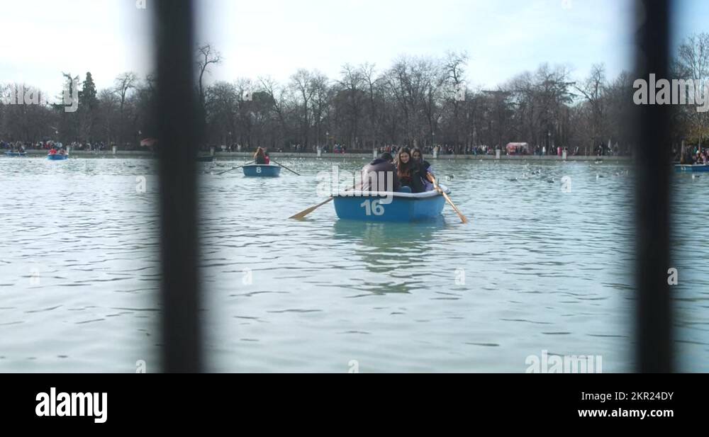 People paddling a boat on a lake inside the famous "El Retiro" park in ...