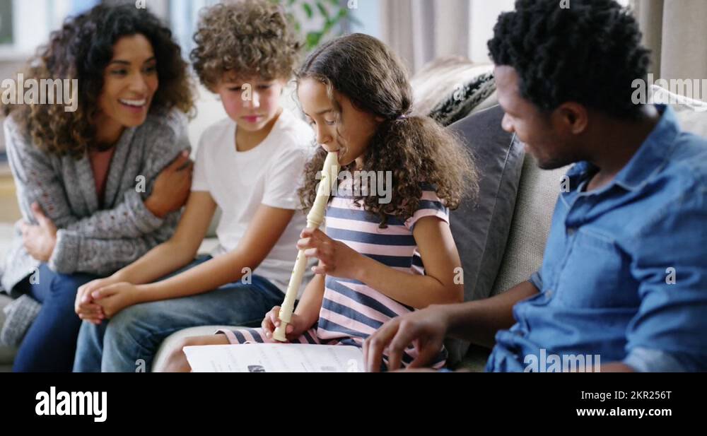 Little girl playing a recorder, family clapping and bonding in the ...