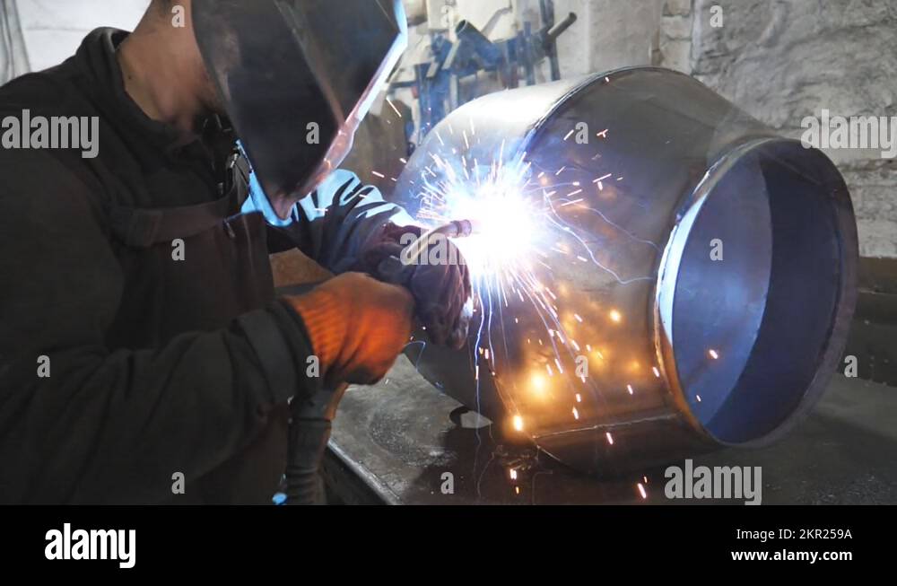 Welder doing joint between two steel details. Man welding parts of the ...