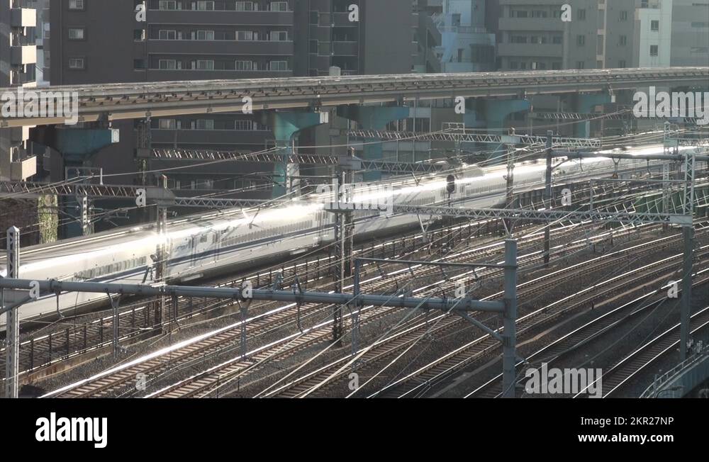 Reflection of a high speed bullet train riding through Tokyo in Japan ...