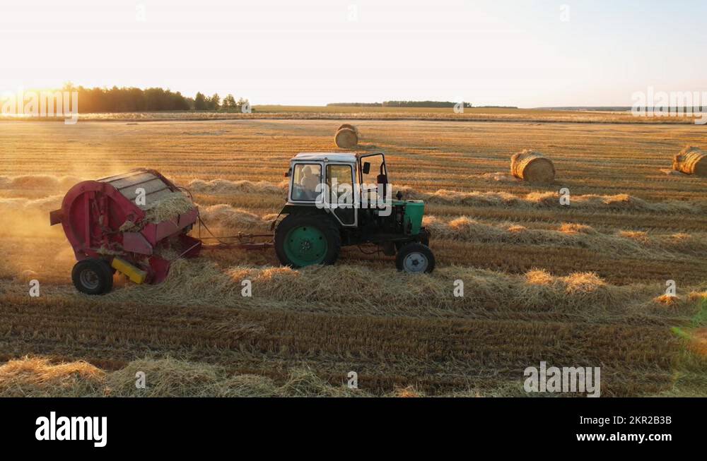 Tractor collecting hay and making haystacks. Tractor Making Hay Bales ...