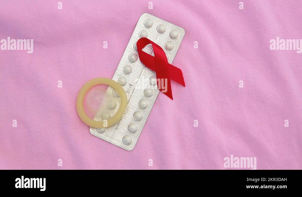 Contraceptive pill packet with condom with red ribbon Stock Video ...