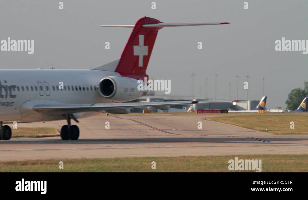 helvetic airways fokker f100 plane taxis to the runway for take off ...