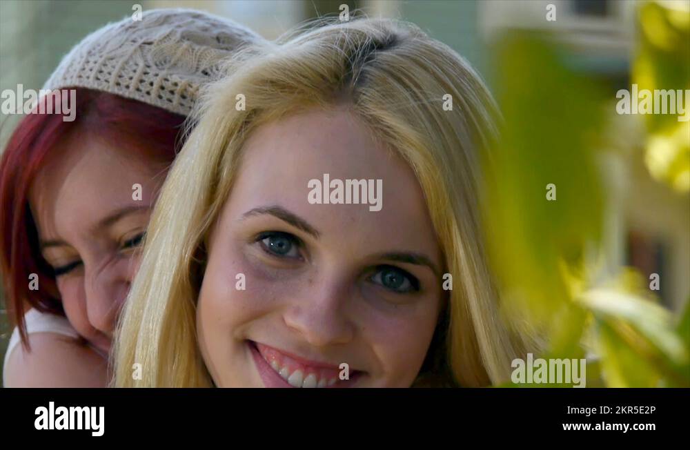 Pretty Girl Surprises Her Friend With A Hug And Kiss On The Cheek Stock ...