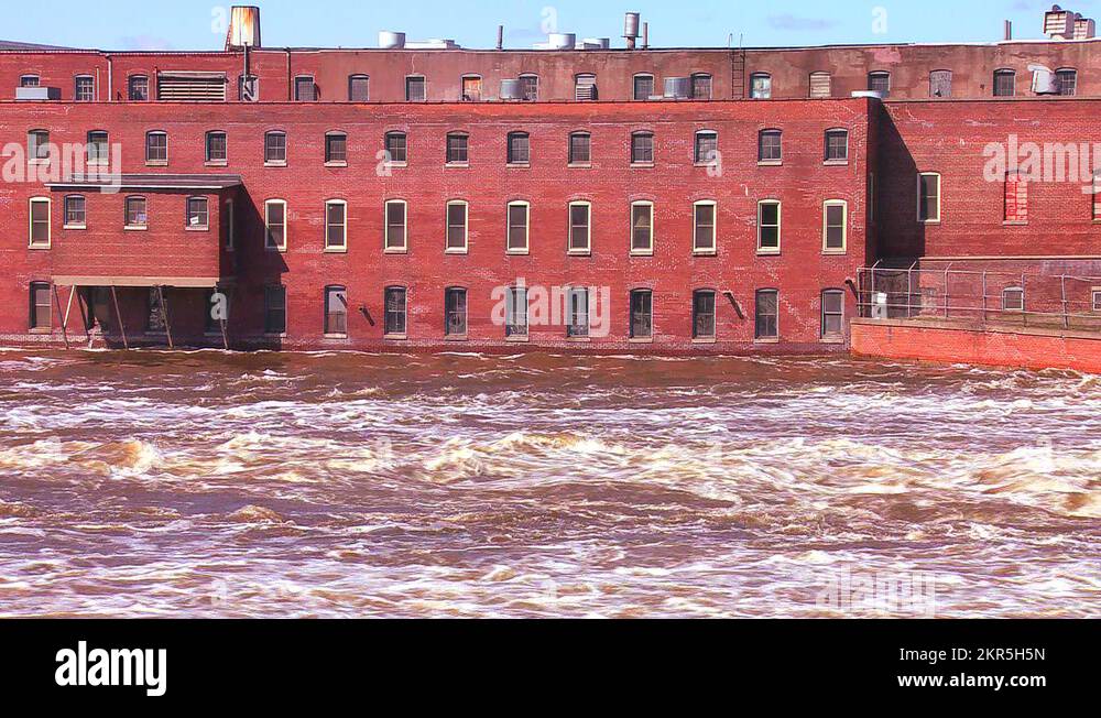 A flooding river flows past an old factory Stock Video Footage - Alamy