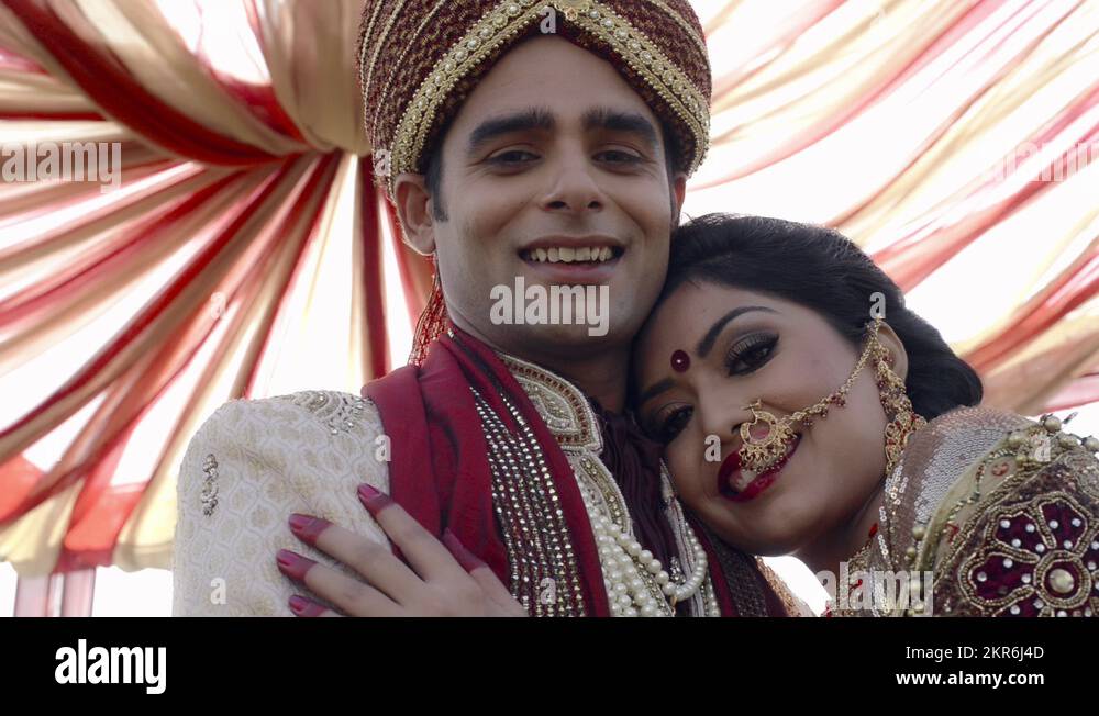 Indian bride and groom in traditional wedding dress posing under a ...