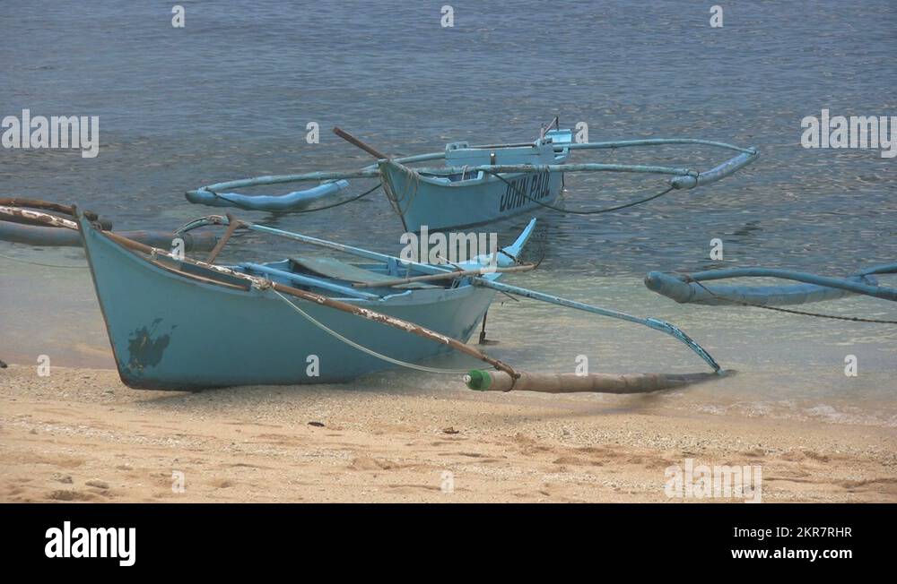 Traditional filipino Banka outrigger boat laying on a beach in ...