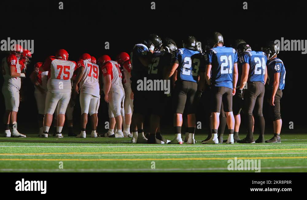 Football teams break their huddles and then line up to start the next ...