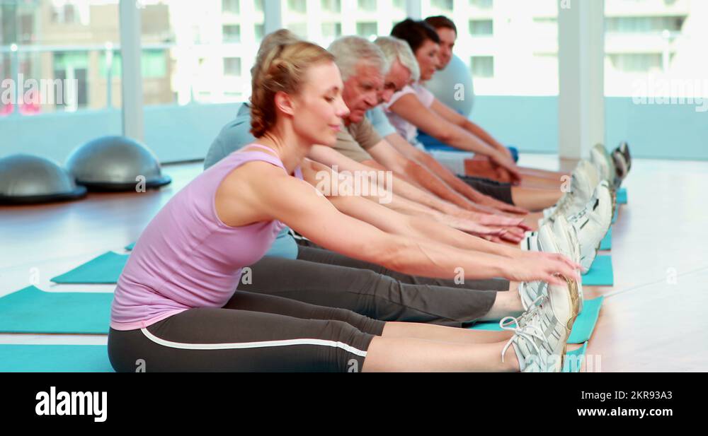 Exercise class stretching and touching their toes Stock Video Footage ...