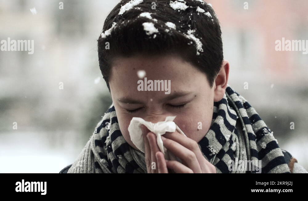 Sick teenage boy sneezing in snowy weather HD Stock Video Footage - Alamy