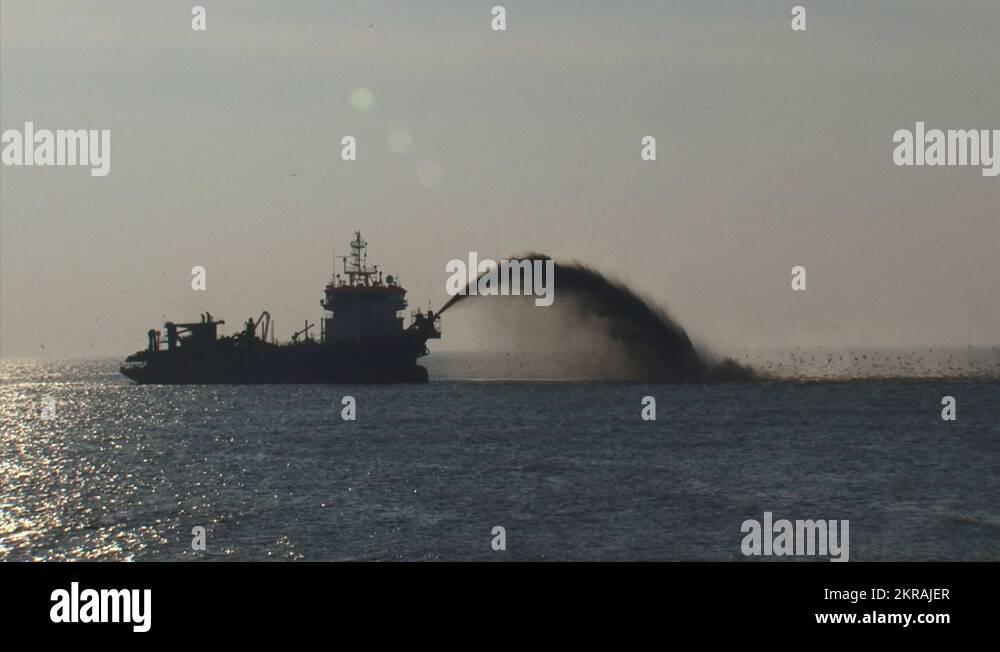 Trailing suction hopper dredges rainbowing near seawall + zoom out ...