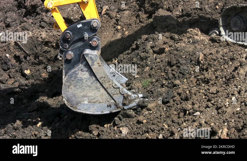 Excavator bucket digging a hole. Earthworks dig on a building site ...