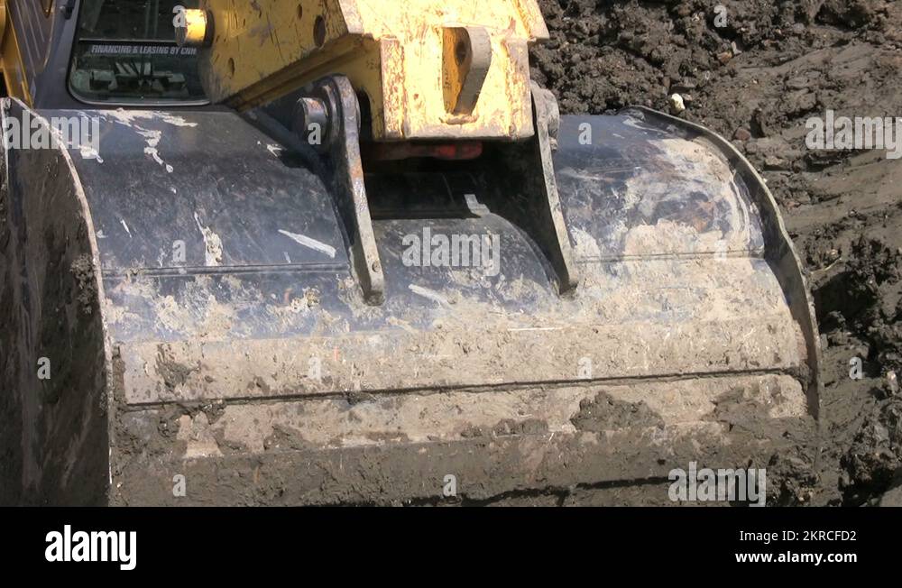 Excavator bucket digging a hole. Earthworks dig on a building site ...