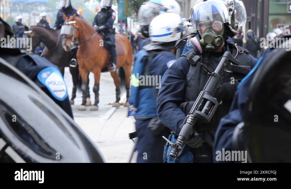 Riot officers stand by with automatic fire weapon and gas masks Stock ...