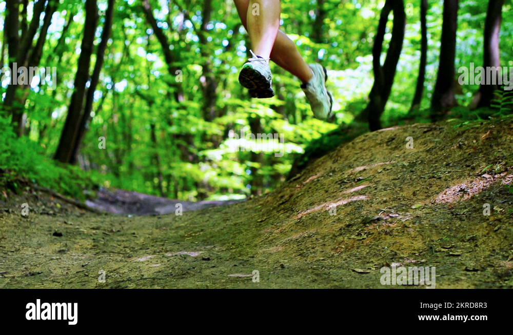 Woman jumping on path in forest, closeup, slow motion shot at 240fps ...
