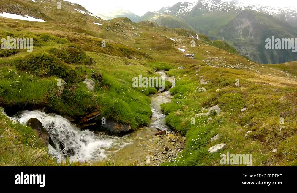 Alps landscape. Cascade on small mountain stream in Alps, water is ...
