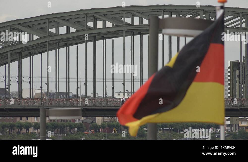 German flag wave Hohenzollern bridge train pass landmark Koln city ...