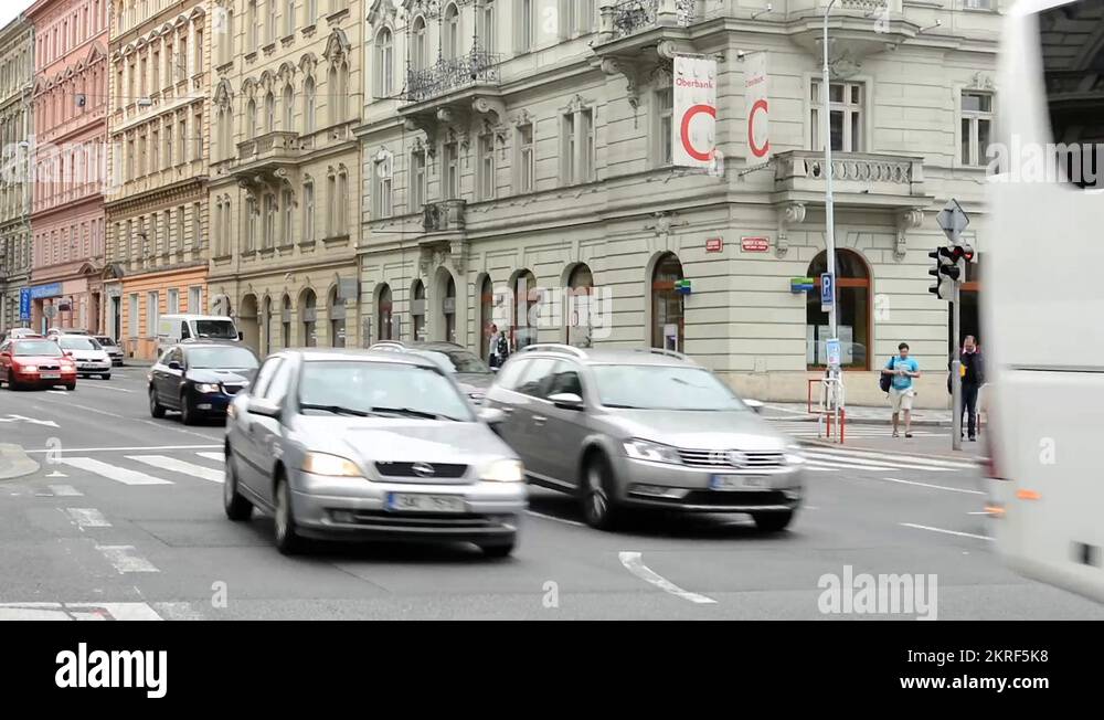 urban street with passing cars and pedestrian crossing: people walking ...