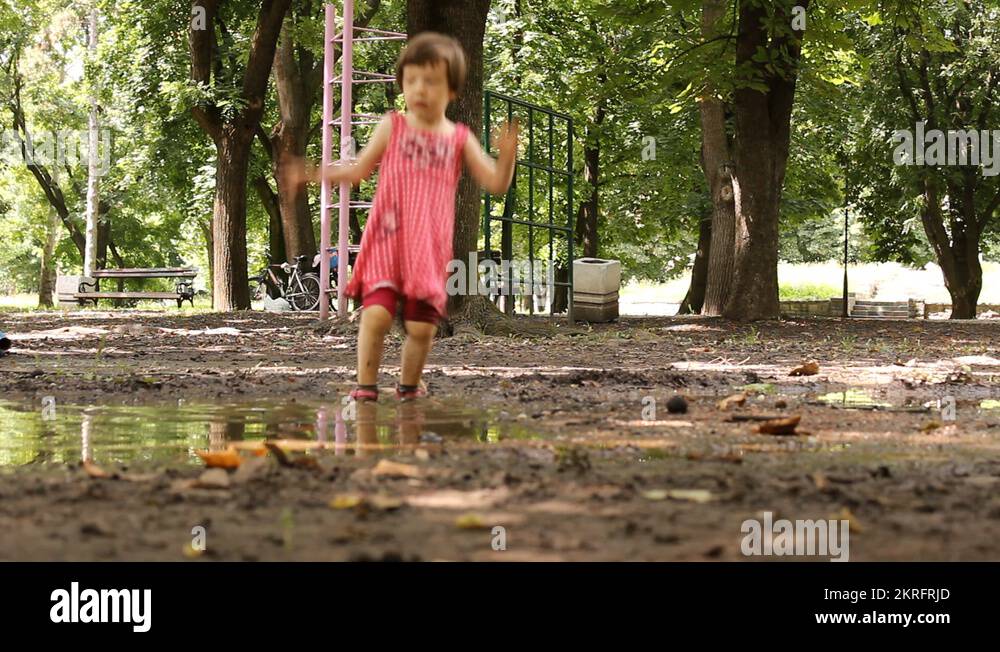 little girl jumping playing in the puddle of mud Stock Video Footage ...