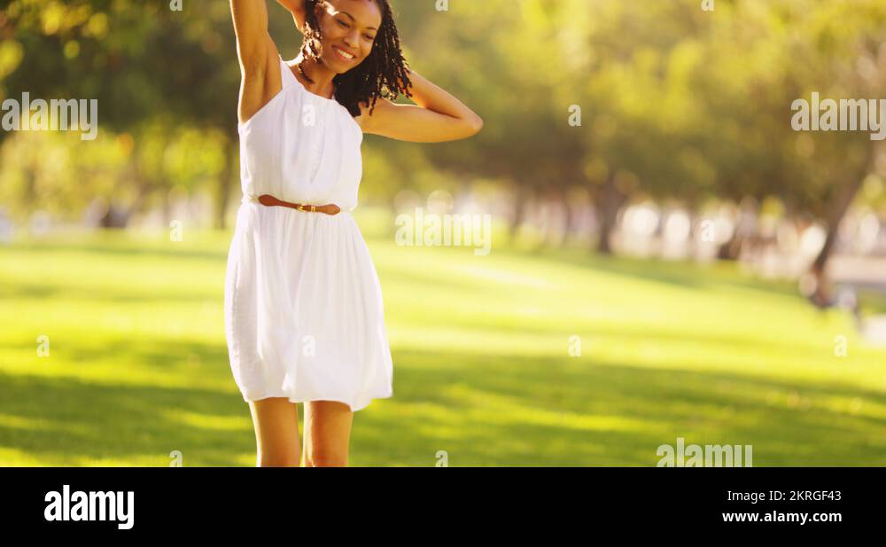 Gorgeous Black Woman Wearing White Dress Standing In A Field Stock
