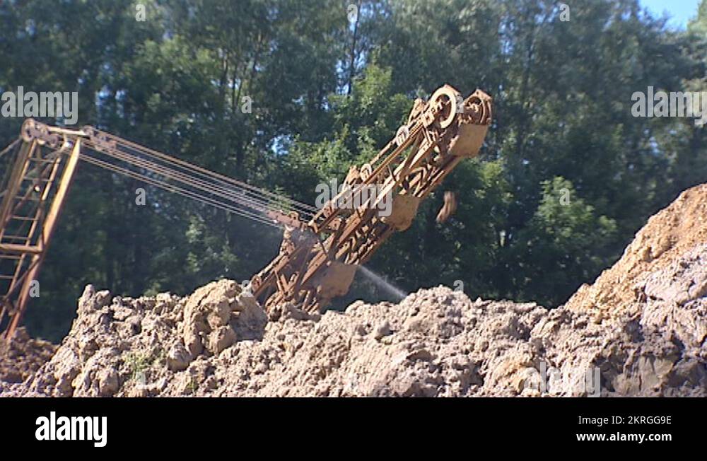 Pug milling machine with rotating blades scrapes clay from piles of ...