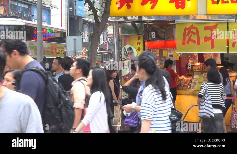 Pan left crowded downtown Hong Kong tourist people cross busy road ...