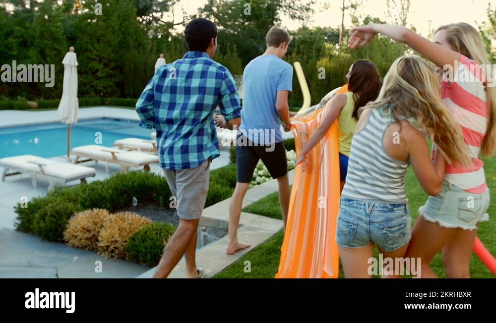 Group Of Friends Have Fun At A Pool Party, Hug, Give Piggyback Rides ...