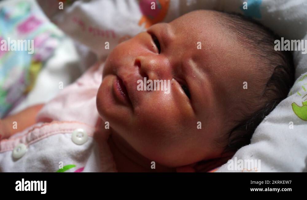 Newborn baby trying to open eyes and see the world for the first time ...