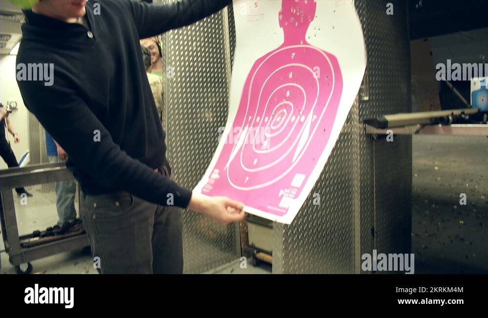 Man admiring his shooting at a gun range with pink target Stock Video ...