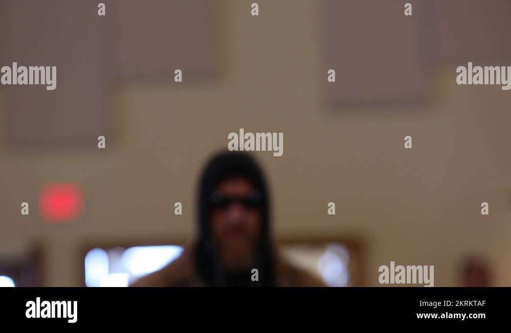 Hooded man aims his target with a pistol/gun Stock Video Footage - Alamy