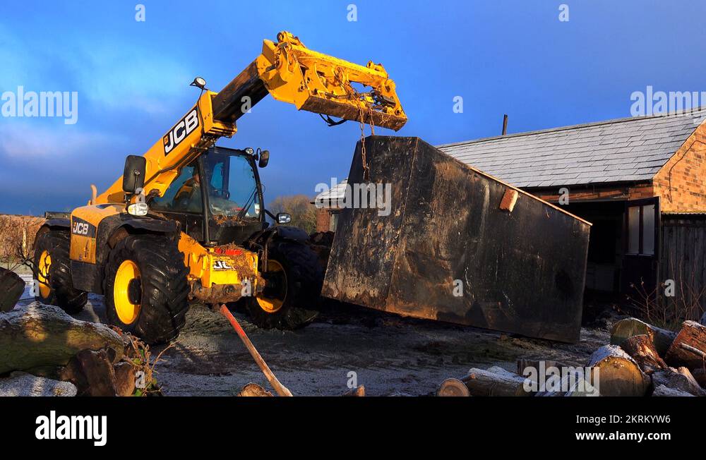 building construction - jcb tractor loader lifting large scrap metal ...