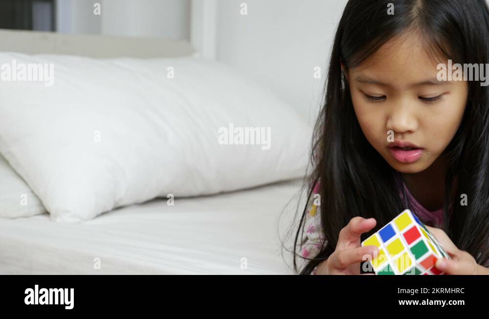 4K Video : Little Asian girls playing rubik cube on the bed together ...